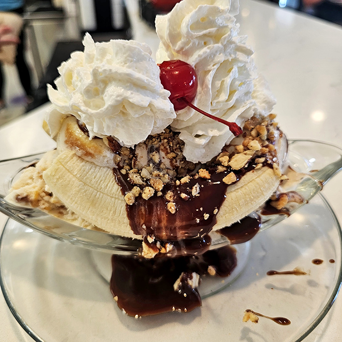 The banana split arrives like dessert royalty&mdash;whipped cream crown, cherry scepter, and chocolate sauce robes flowing dramatically.