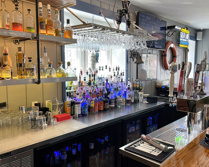 Behind the bar, bottles gleam like treasure under carefully placed lighting, promising craft cocktails and local brews to complement your lakeside feast.