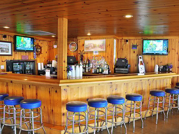 The wooden bar, with its row of blue stools, has witnessed countless island stories, ferry tales, and the occasional exaggerated fish-catching saga.