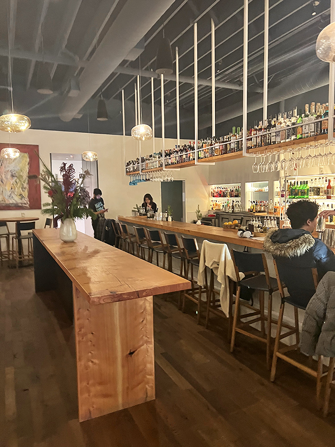 The bar at Piccino: where wooden warmth meets bottle geometry, creating the perfect backdrop for your "I've discovered something amazing" story.