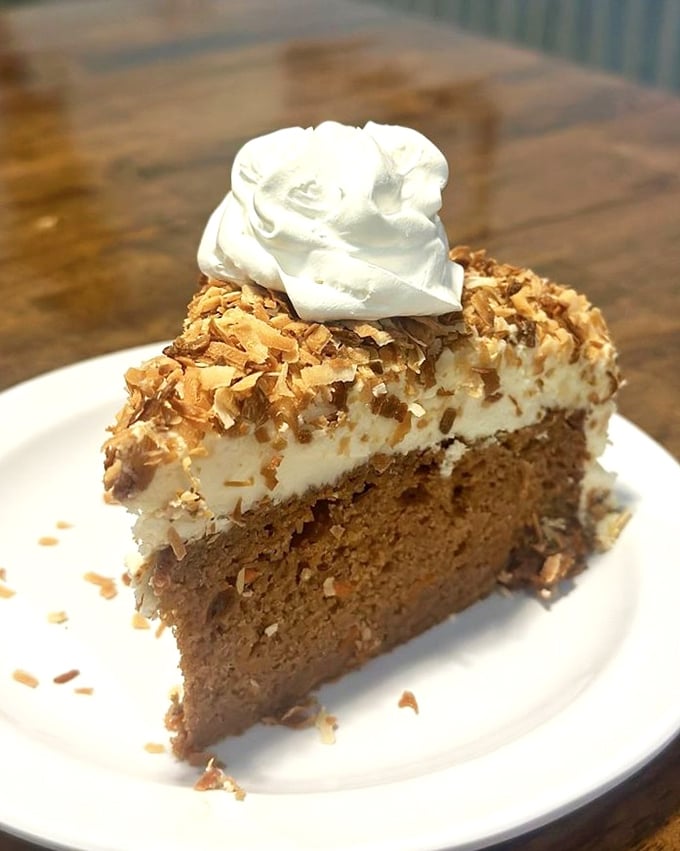 Coconut cake that makes you question why you "saved room for dessert" instead of ordering two slices upfront. That whipped cream crown is well-deserved.