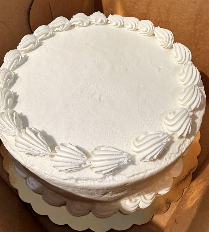 This classic white cake with its perfectly piped borders isn't just dessert; it's a blank canvas for celebration, waiting to commemorate life's sweetest moments.