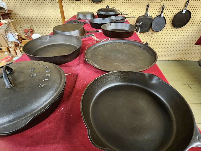 Cast iron cookware displayed on red fabric – these seasoned pans have served more family meals than any modern non-stick ever will.