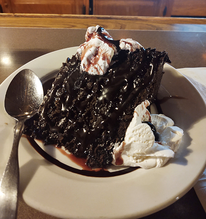 A chocolate cake so rich it should come with its own tax bracket. The ice cream melting alongside creates that hot-cold symphony that makes dessert worth the calories.