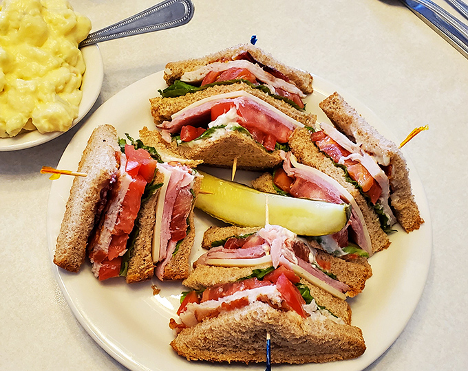 A club sandwich built like a skyscraper of deliciousness. The toothpicks aren't decoration &ndash; they're structural engineering.