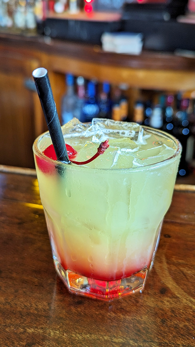 A cocktail that's dressed for success with its cherry red bottom and lime green top. Like a tropical sunset in a glass, with a kick.