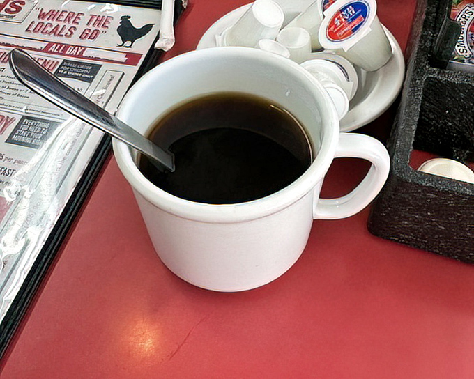 A simple cup of coffee on a red tabletop&mdash;the unsung hero of every great diner experience and the perfect companion to Ruth's breakfast masterpieces.