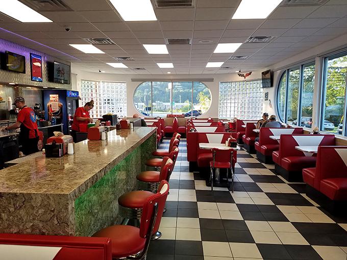 The counter offers front-row seats to the culinary theater, where red stools await patrons and the checkered floor sets the stage for diner magic.