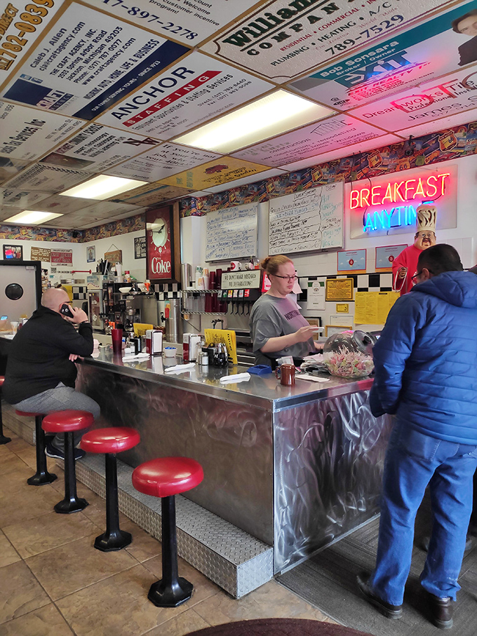 The counter &ndash; where breakfast magic happens. Those red stools have supported generations of hungry patrons waiting for their slice of diner heaven.