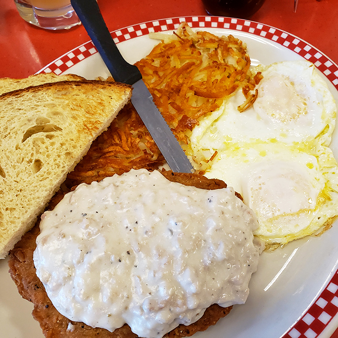 Country fried steak smothered in peppery gravy with sunny-side up eggs &ndash; a breakfast so hearty it could fuel a day of chopping wood.