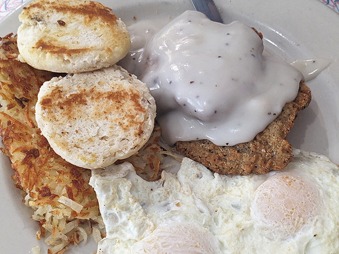 Country fried steak smothered in pepper gravy alongside sunny-side-up eggs. A plate that says "You won't be hungry again until dinner" in the most delicious way possible.