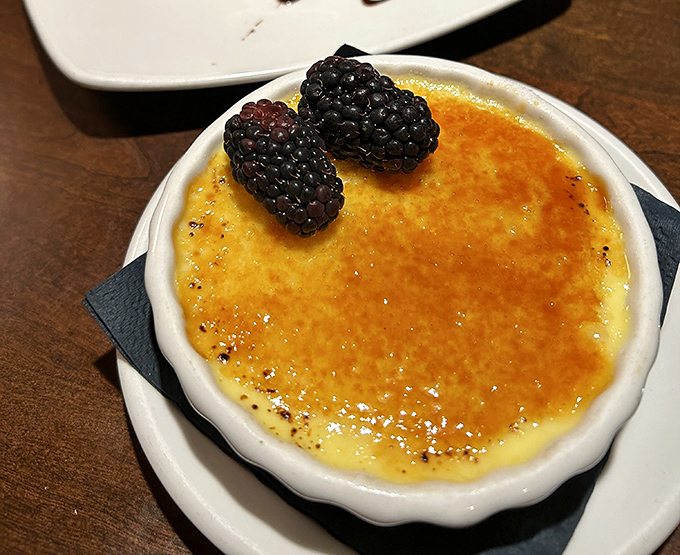 The cr&egrave;me br&ucirc;l&eacute;e's perfectly torched sugar crust awaits your spoon's satisfying crack, topped with plump blackberries for a touch of tartness.