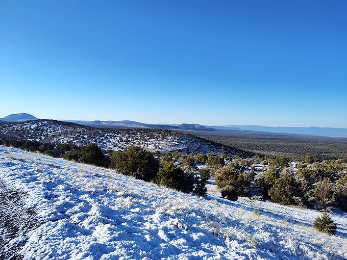 Snow dusts the landscape like powdered sugar on nature's pastry, adding a rare seasonal twist to this typically sun-drenched vista.