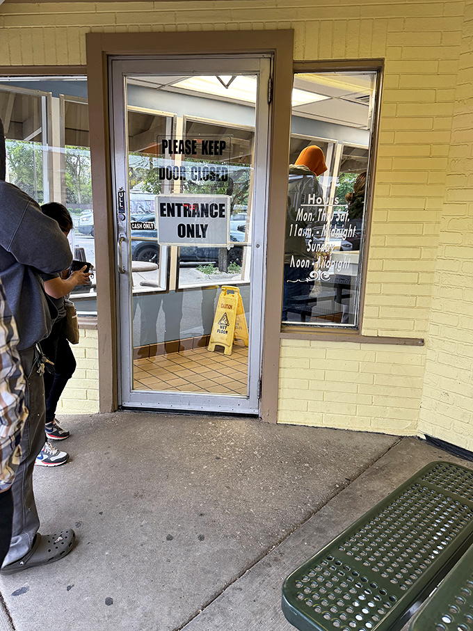 The entrance&mdash;where hopes are high and stomachs are empty. Hours posted clearly because some pilgrimages require planning.