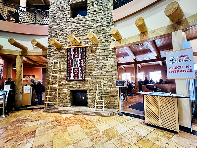 Stone, wood, and textile come together in this grand entrance hall, where a traditional ladder against the fireplace signals you've entered a space that honors heritage.