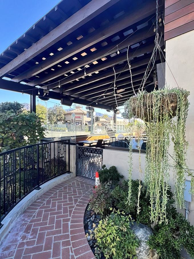 A charming entrance pathway lined with greenery and string lights. The kind of welcoming approach that promises good things are waiting just around the corner.