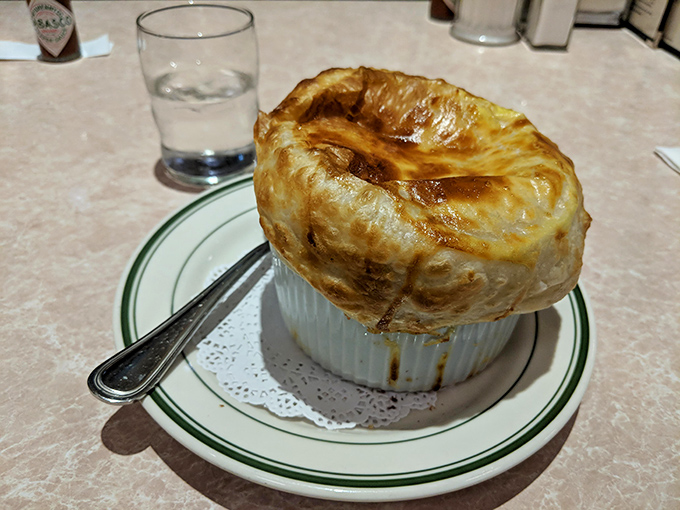 French onion soup crowned with a golden puff pastry dome that's basically edible architecture at its finest.