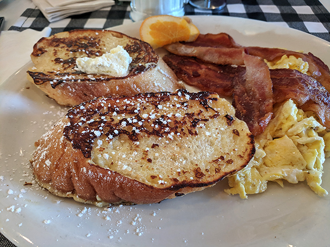 French toast that renders syrup optional. Dusted with powdered sugar, paired with crispy bacon &ndash; breakfast nirvana on a plate.