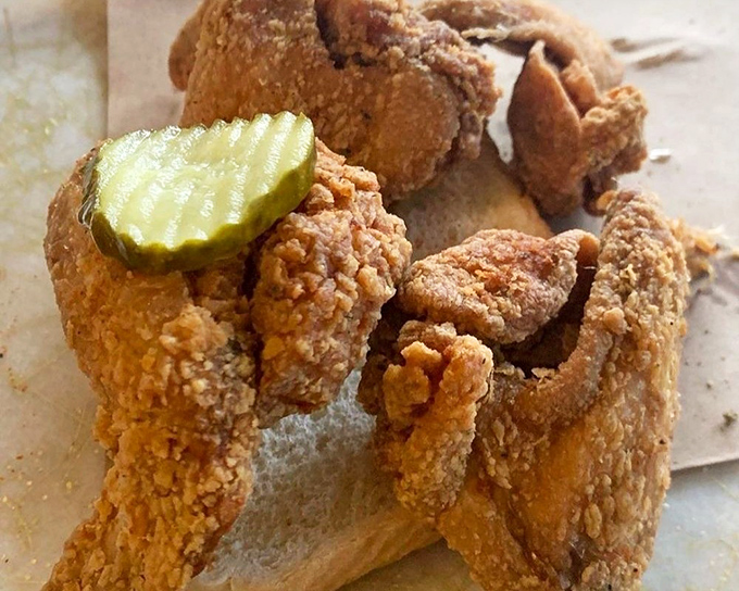 Fried chicken wings with a pickle chaperone—crispy, golden armor protecting juicy meat within. One bite and you'll understand why napkins were invented.