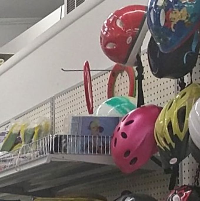 Colorful helmets hang ready to protect adventurous heads, because safety gear shouldn't cost more than the actual bike or skateboard itself.