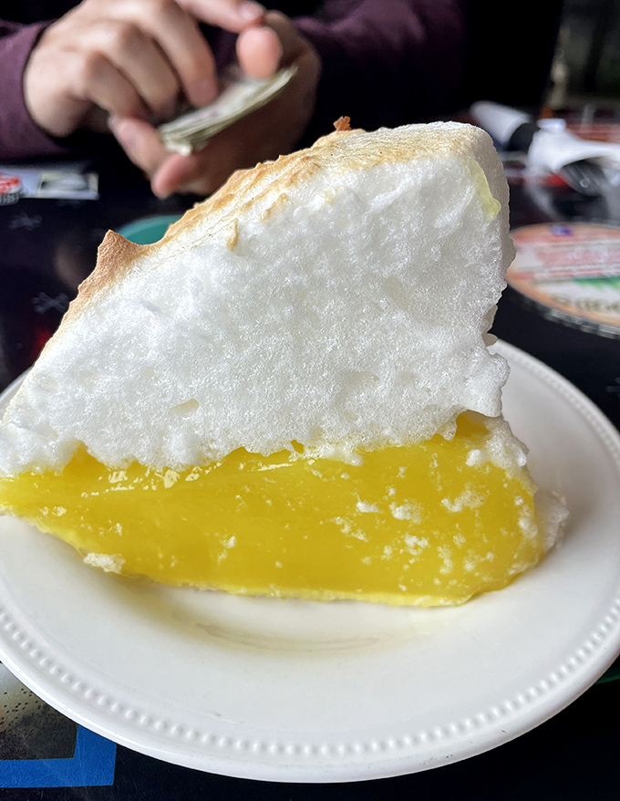 The legendary lemon meringue pie – a cloud of sweet meringue floating above sunshine-yellow filling that makes you believe in dessert divinity.
