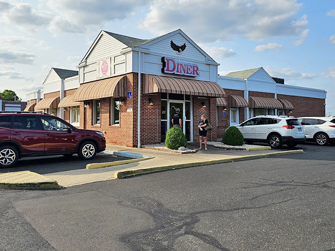 The Eagle Diner's exterior combines brick solidity with welcoming design. Its corner position in the parking lot signals "this is the place" to passing drivers.