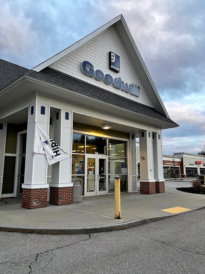 The Somersworth Goodwill welcomes shoppers under dramatic skies, its clean architectural lines promising treasures within for the patient hunter.