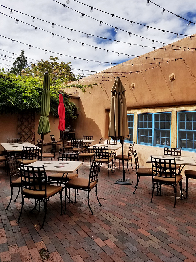 Daytime on the patio reveals the true colors of Santa Fe. Those blue windows and adobe walls frame outdoor dining like a Georgia O'Keeffe painting.