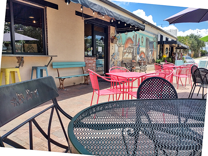 The outdoor seating area pops with color from turquoise benches and pink chairs, proving that in Florida, even the furniture knows how to have fun.