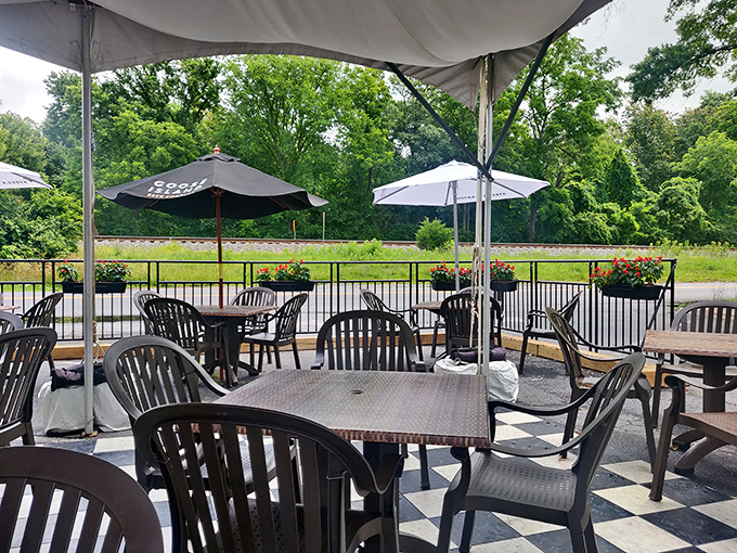 The outdoor seating area offers a peaceful retreat with umbrellas for shade and greenery all around&mdash;nature's dining room.