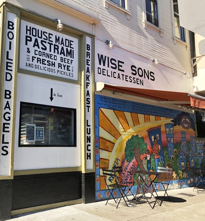 The exterior proudly announces "HOUSE MADE PASTRAMI & CORNED BEEF" like a delicious billboard. Some promises are worth traveling across town to verify.