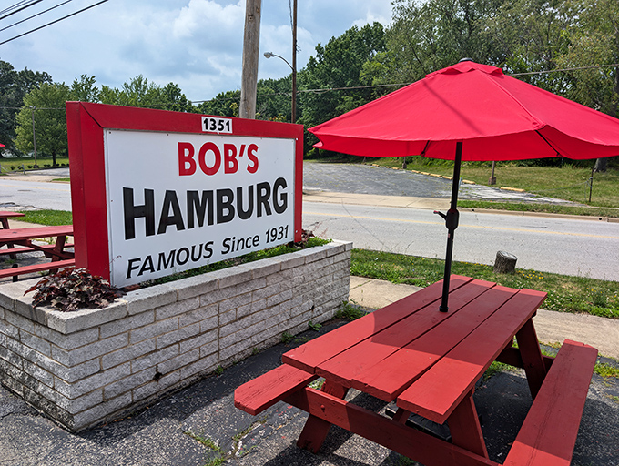 Red picnic tables under matching umbrellas—where summer memories are made one burger at a time in this Akron institution.