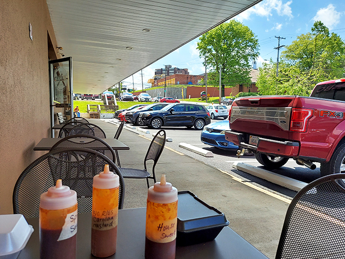 Outdoor seating with the holy trinity of barbecue sauces standing guard. Sweet, spicy, and house special&mdash;choose your adventure wisely.