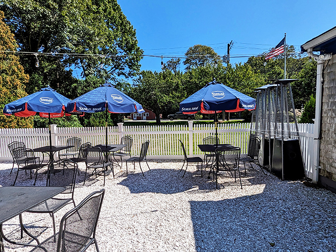 The outdoor seating area: where summer breezes, blue umbrellas, and post-lobster roll contentment come together in perfect harmony.