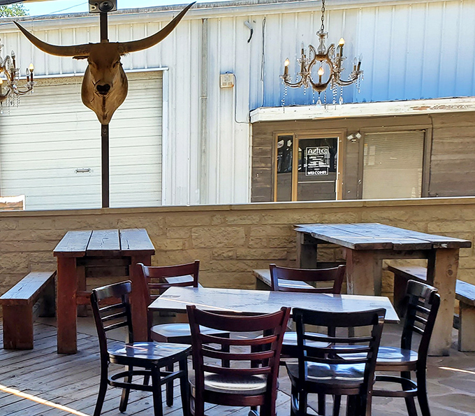 The outdoor patio combines longhorn authenticity with chandeliers, because in Texas, even casual dining deserves a touch of grandeur.