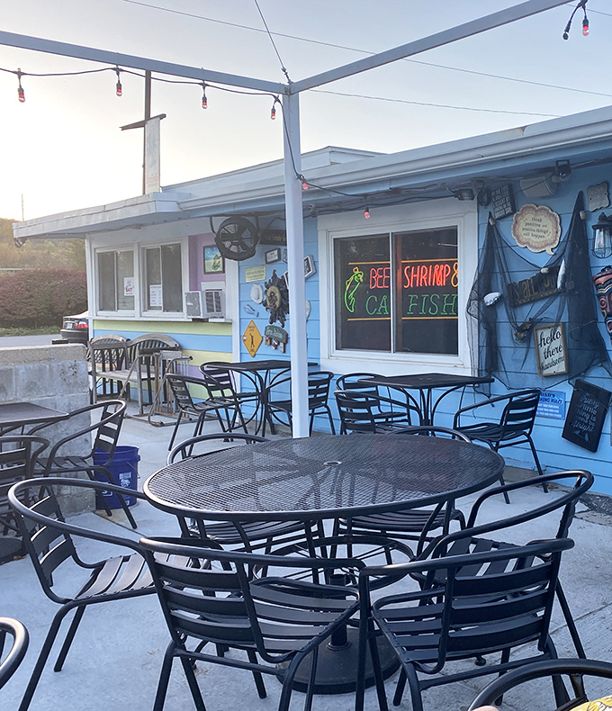The outdoor patio awaits fair-weather diners. Simple metal furniture under string lights creates the perfect setting for summer evening seafood sessions.