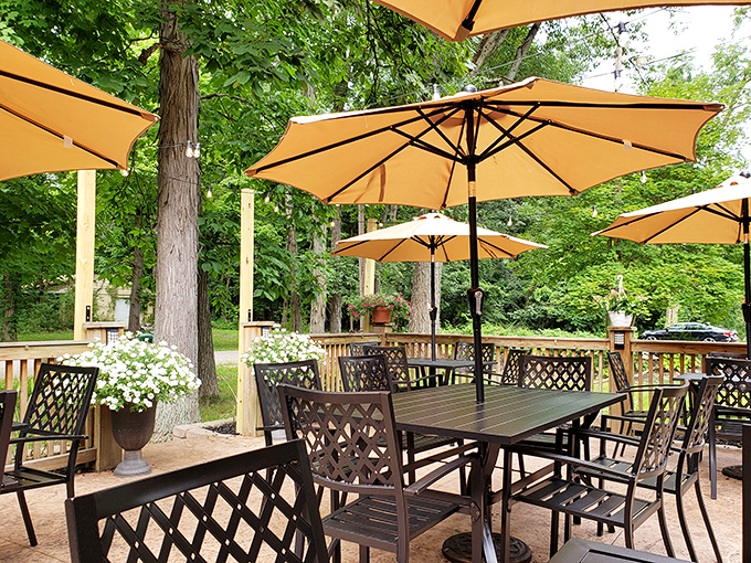 Dappled sunlight filters through the trees onto this outdoor oasis, where umbrellas stand guard against Ohio's unpredictable weather patterns.