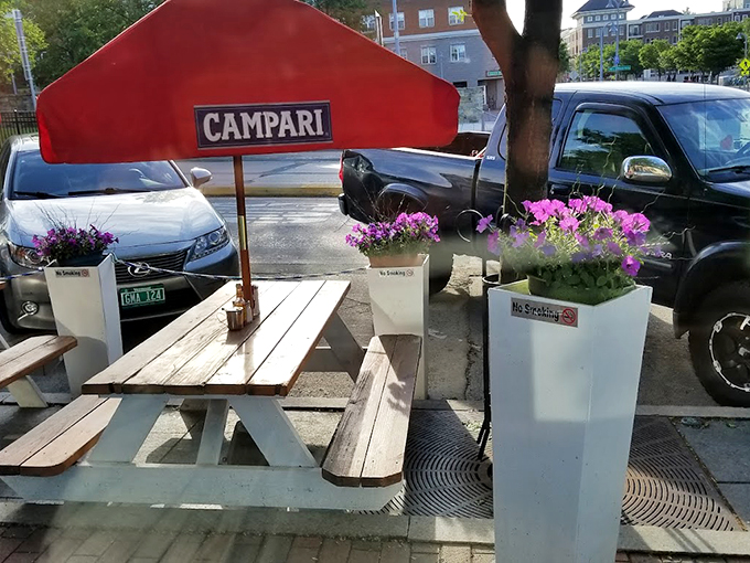 Outdoor seating that captures Vermont's fleeting summer glory. Flower boxes and a red umbrella create an al fresco experience worth waiting all winter for.