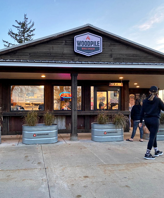 As evening approaches, Woodpile BBQ Shack glows like a beacon for the hungry. The "OPEN" sign might as well say "SALVATION."