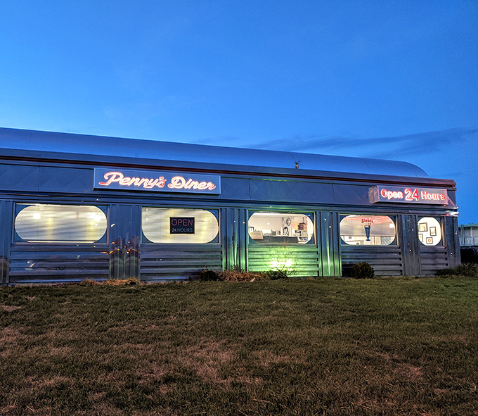 As evening falls, Penny's neon glow transforms into a roadside oasis, promising comfort food and bottomless coffee around the clock.