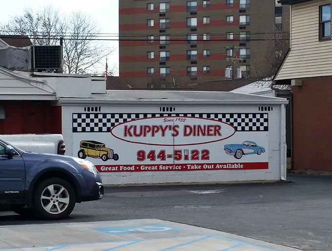 The iconic checkerboard trim and vintage car imagery on Kuppy's exterior wall isn't just decoration&mdash;it's a promise that inside, time-honored traditions are still respected.