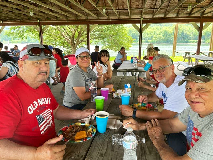The outdoor dining area where BBQ brings strangers together as temporary family. Those colorful cups hold more than drinks—they hold celebration.