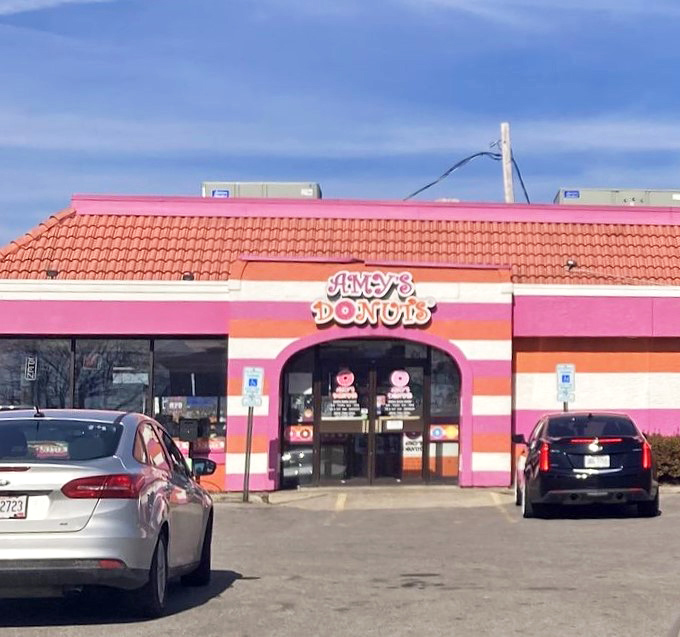 The parking lot view: where anticipation builds and willpower begins to crumble at the mere sight of those pink and orange stripes.