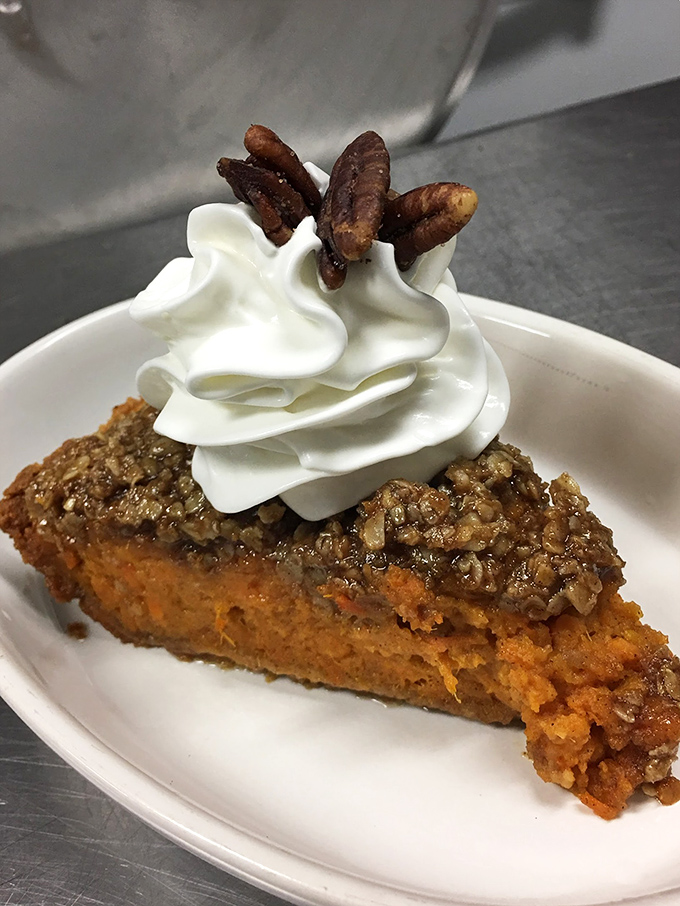 Sweet potato pie topped with candied pecans and whipped cream – proof that dessert isn't just the end of a meal, but sometimes the whole point of one.