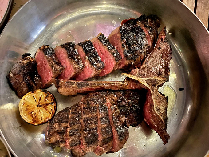 A perfectly cooked porterhouse steak, sliced to reveal a ruby interior that makes vegetarians question their life choices.