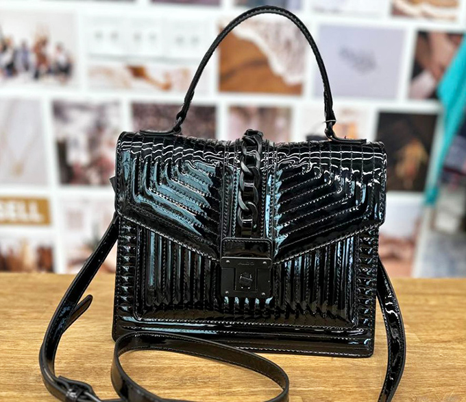 This structured black handbag looks like it should come with its own security detail. Geometric elegance that elevates any outfit from "meh" to memorable.