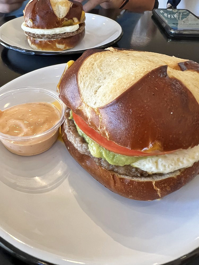 This isn't just a breakfast sandwich&mdash;it's morning salvation. The glossy pretzel bun cradles egg, cheese, and savory goodness with a side of spicy aioli.