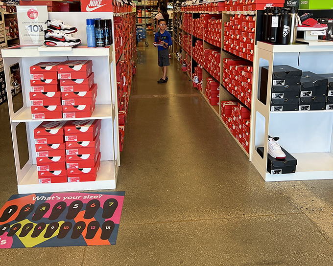 The Nike store's shoe section stretches like a red-boxed runway of possibilities, each pair waiting for its Cinderella moment.