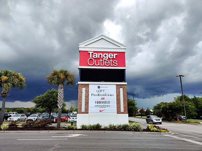 The entrance sign stands like a retail lighthouse guiding bargain seekers safely to shore&mdash;promising Nike, Calvin Klein, and Forever 21 without the full-price pain.