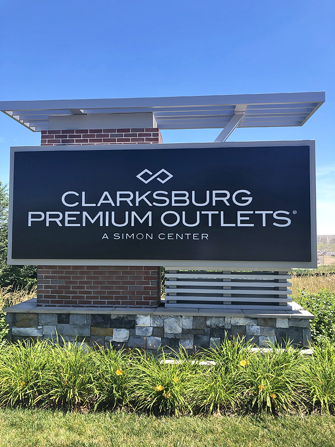 The official welcome sign stands proud against blue skies. Clarksburg Premium Outlets: where your credit card gets a workout but your bank account gets a break.